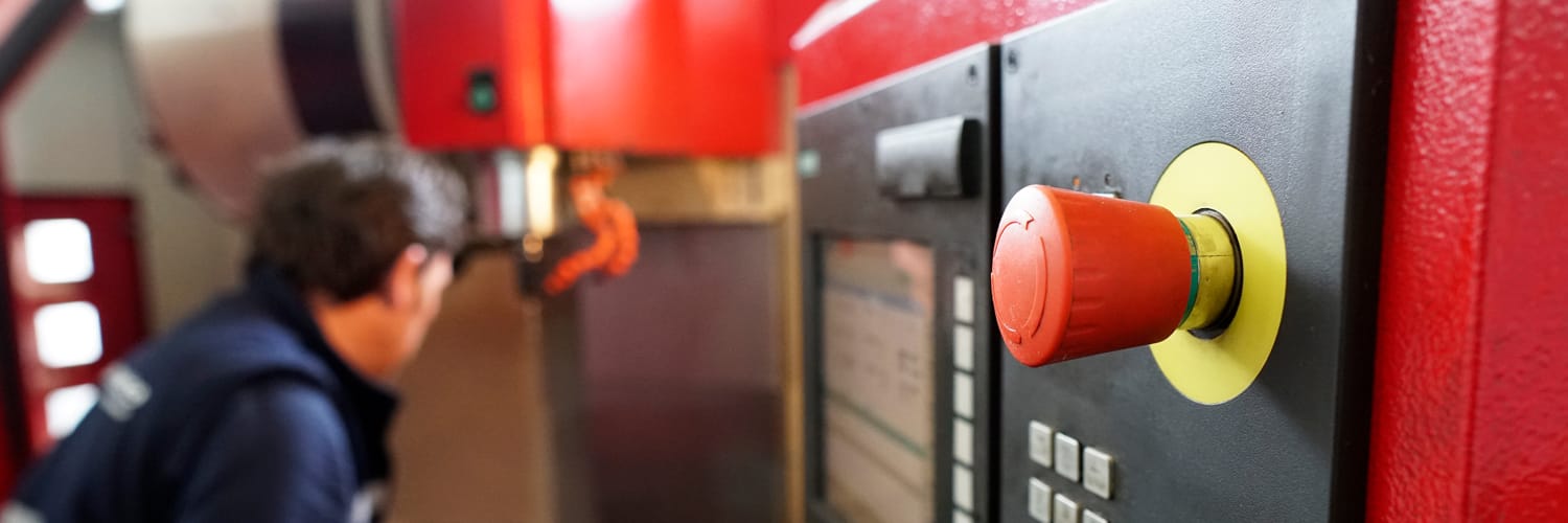 How does an emergency stop button work?